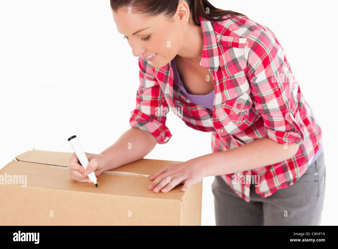 Portrait of a beautiful woman writing on cardboard boxes with a marker ...