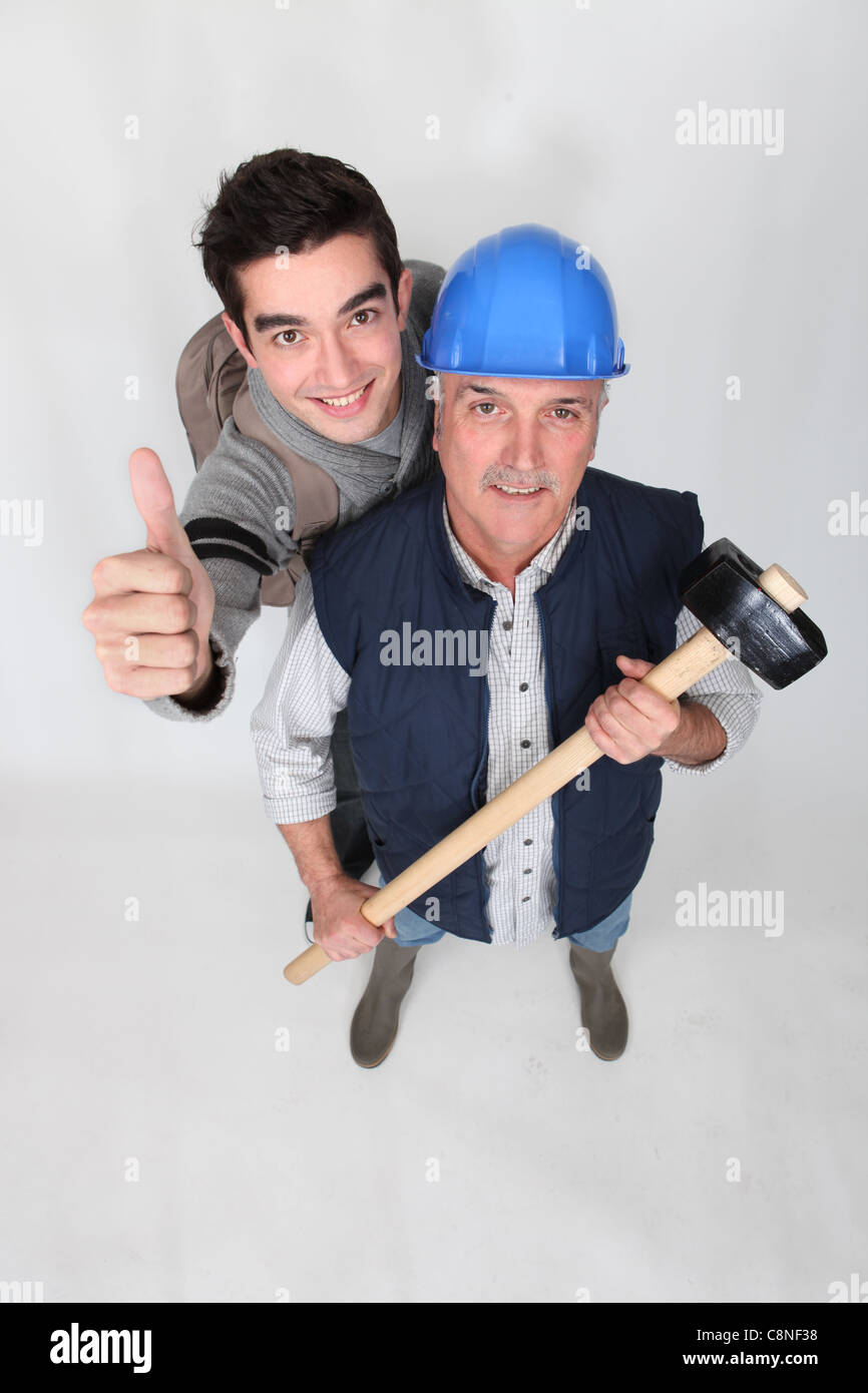 Experienced tradesman posing with his new apprentice Stock Photo - Alamy