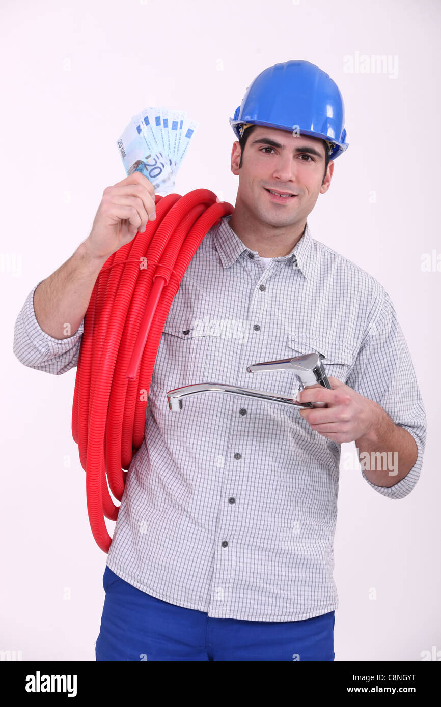Plumber holding banknotes Stock Photo - Alamy