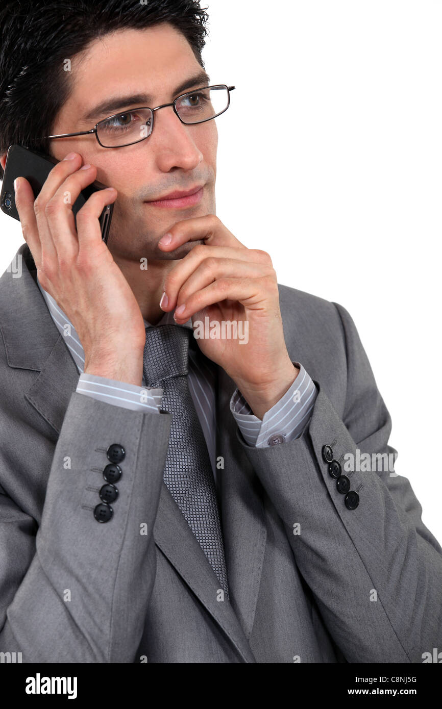 Thoughtful businessman using a cellphone Stock Photo - Alamy