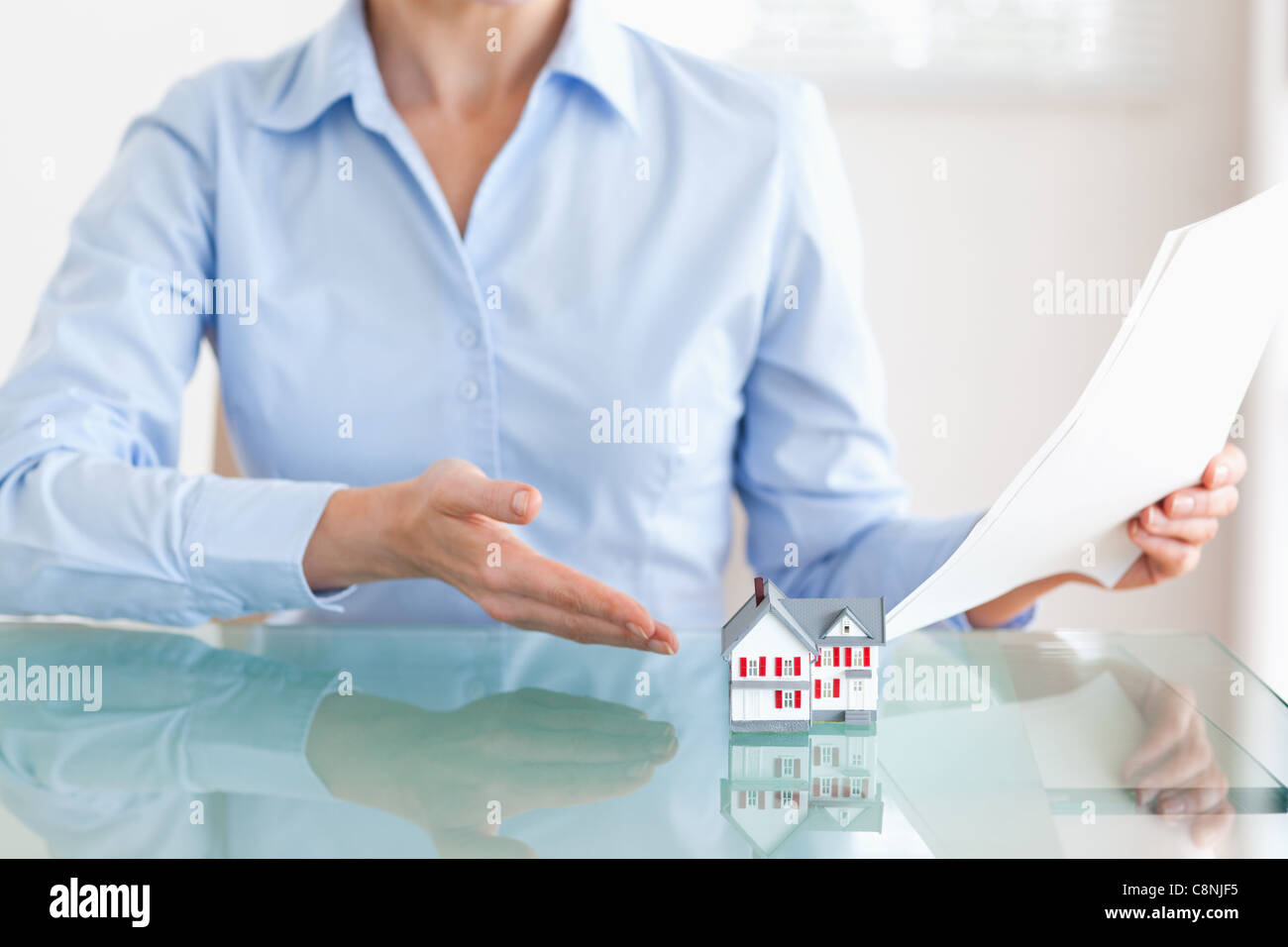 Woman holding papers showing a model house Stock Photo - Alamy