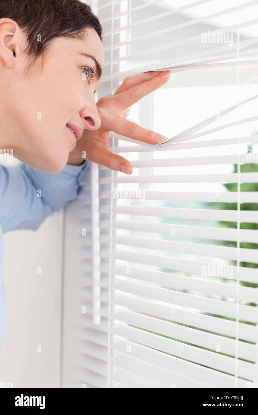 Smiling woman peeking out a window Stock Photo - Alamy