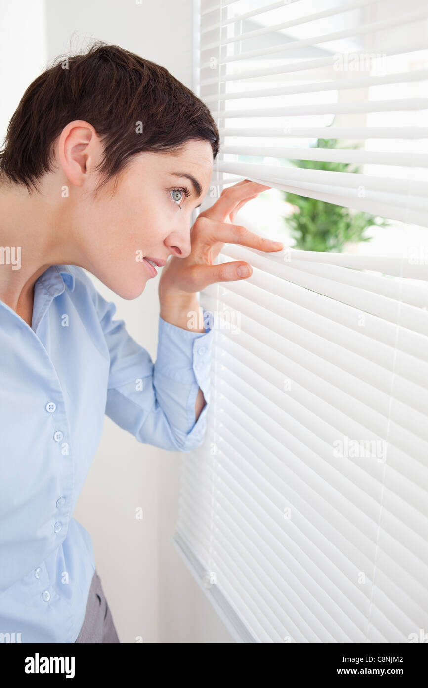 Good-looking woman peeking out a window Stock Photo - Alamy
