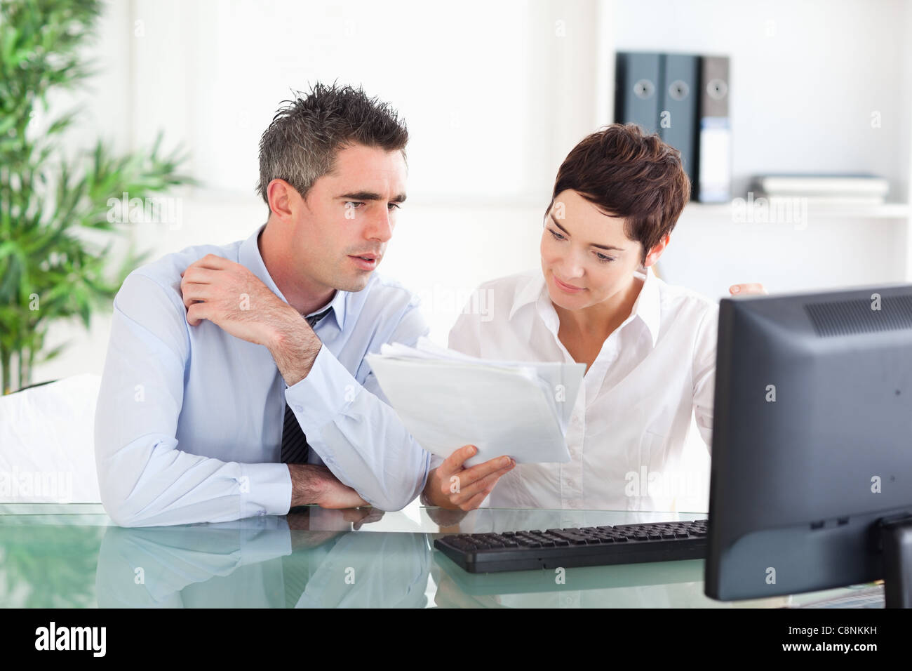 Colleagues looking at folders Stock Photo - Alamy