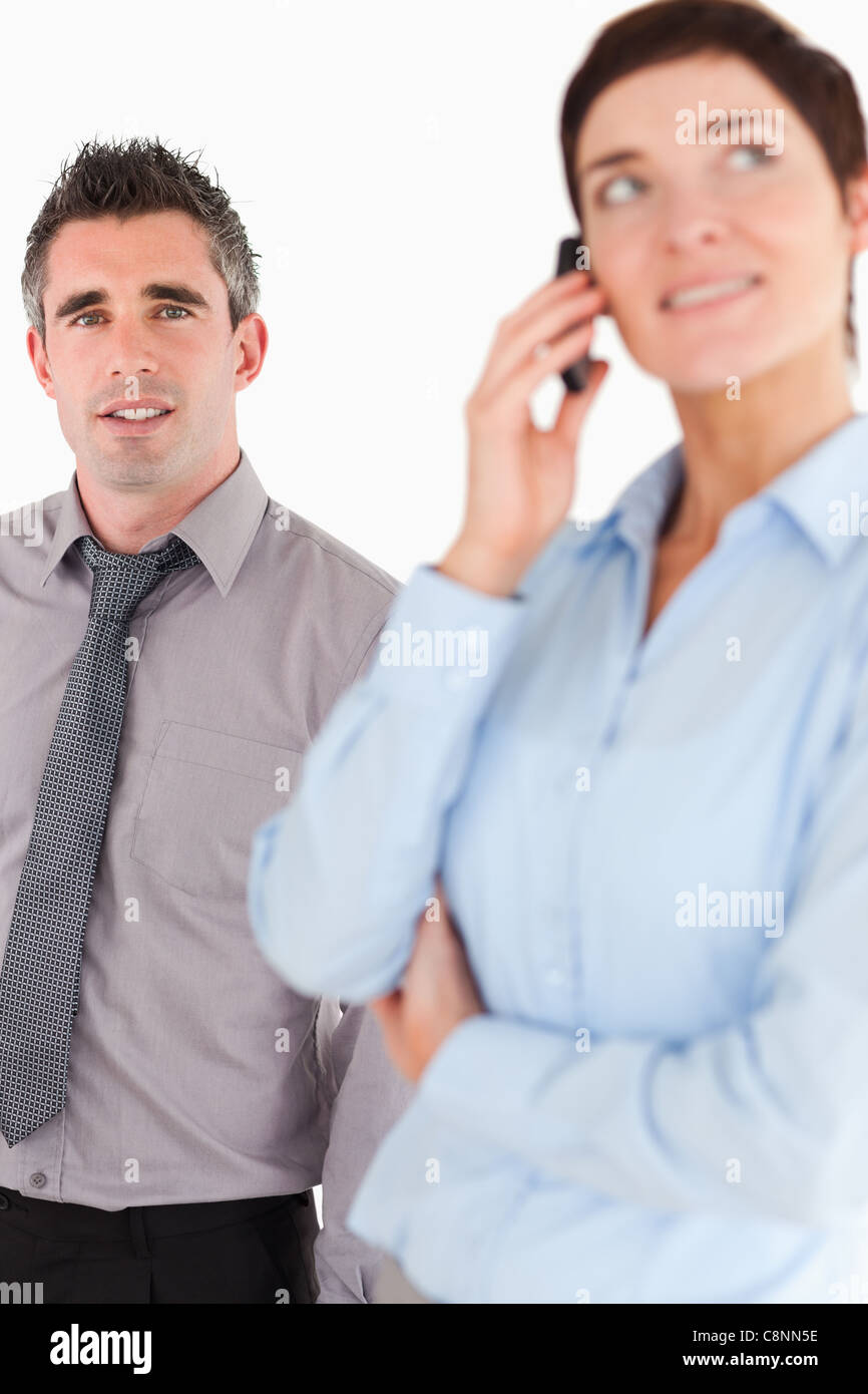 Portrait of a woman on the phone call while her coworker is posing ...