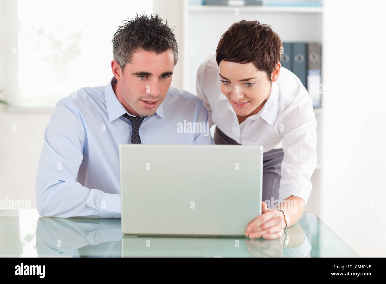 Coworker working with a laptop Stock Photo - Alamy