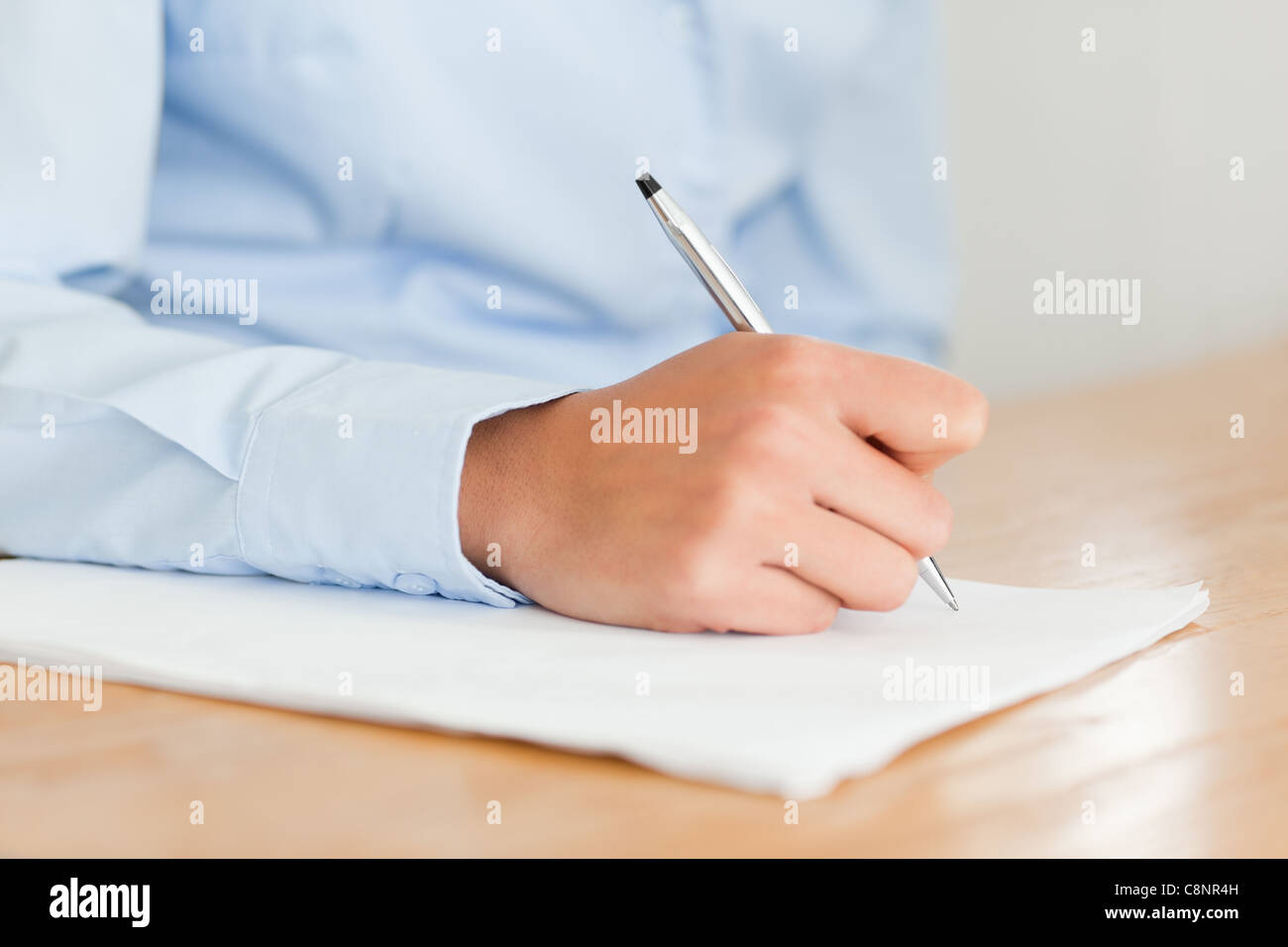 Woman writing on a sheet of paper while sitting Stock Photo - Alamy