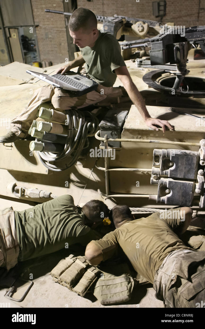 Night crew tank mechanics troubleshoot a tank engine with help from an ...