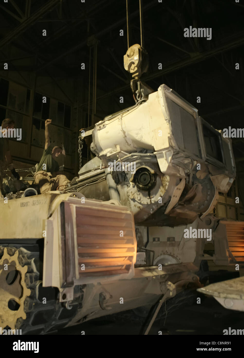 A 1,500 horse power air-gas turbine engine is lowered into an M1A1 ...