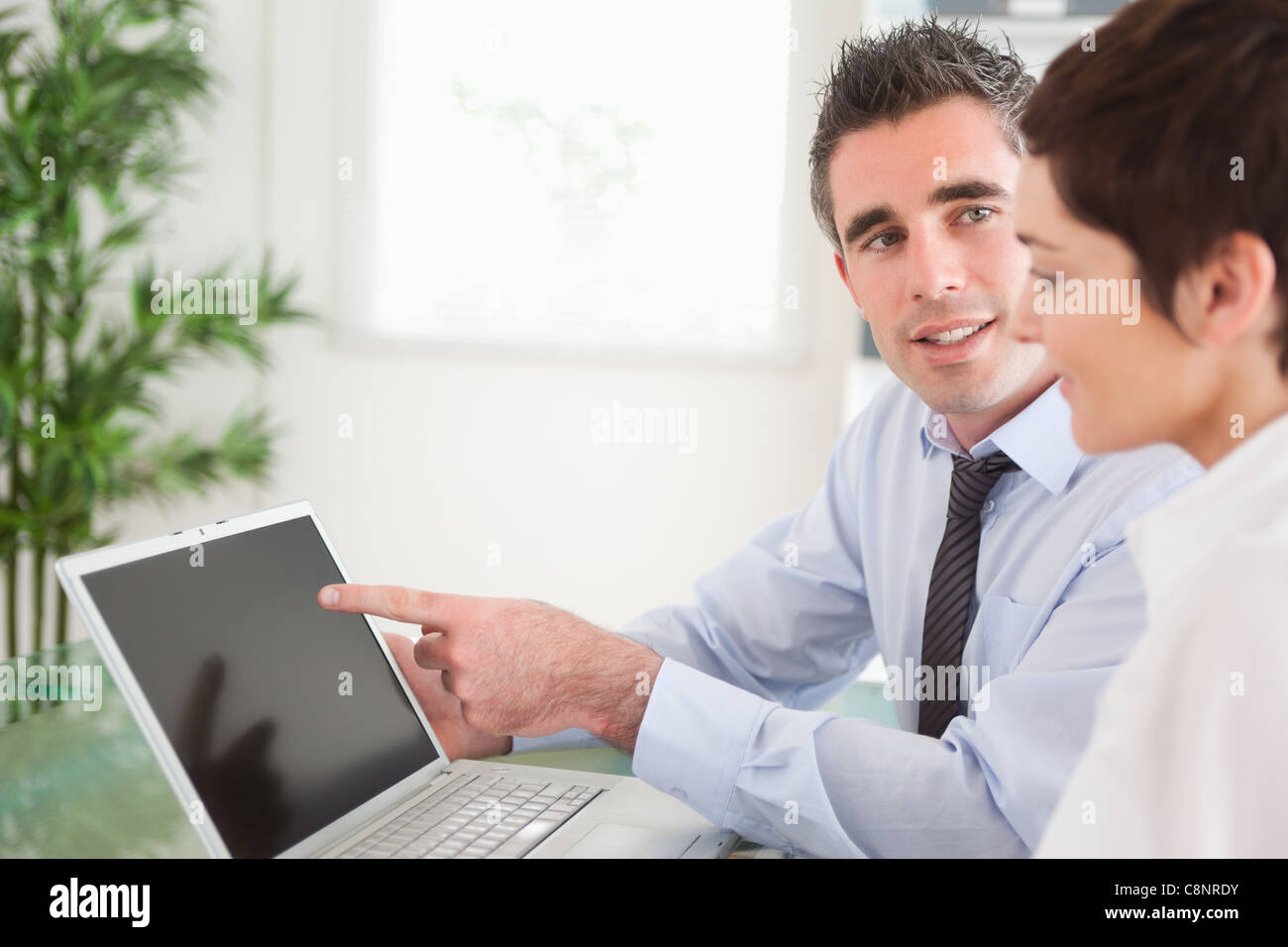 Manager pointing at something to his secretary on a laptop Stock Photo ...