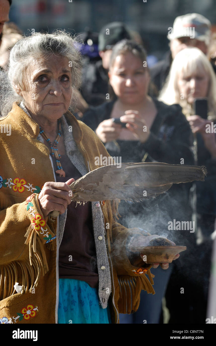 First Nation female elder performing a smudging ceremony, a spiritual ...