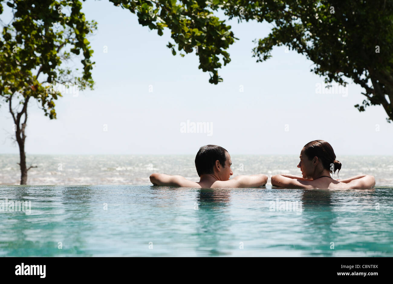 Caucasian couple swimming in infinity pool together Stock Photo - Alamy