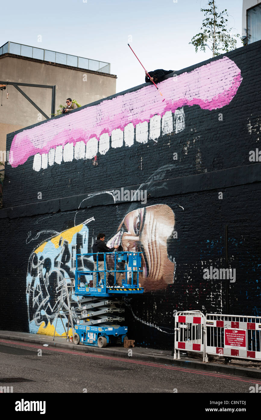 Two Graffiti Artists - could be the "Burning Candy Crew" - decorating a ...