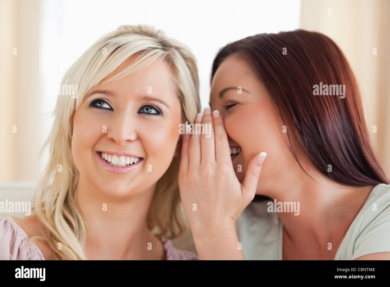 Gorgeous woman telling her friend a secret Stock Photo - Alamy