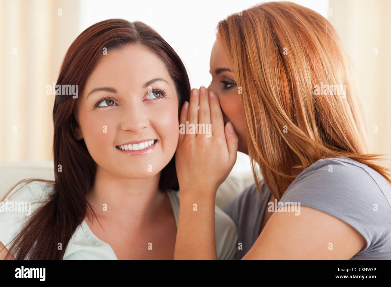 Gorgeous woman being told a secret Stock Photo - Alamy