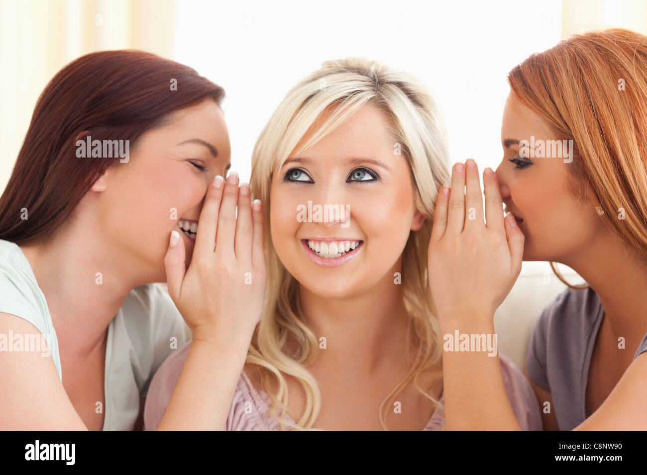 Young woman being told two secrets at a time Stock Photo - Alamy