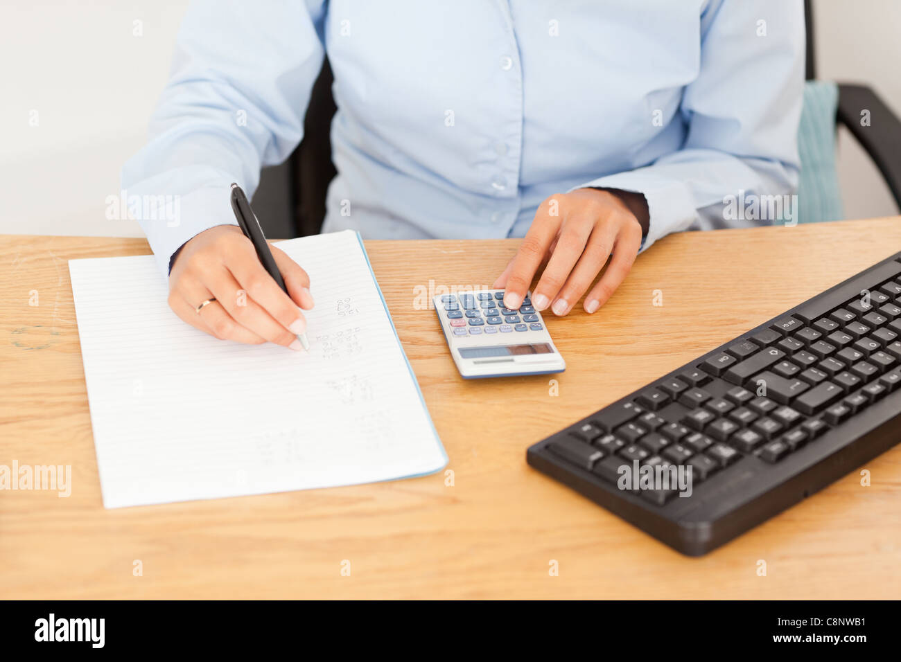 Female accountant writing results on a piece of paper Stock Photo - Alamy