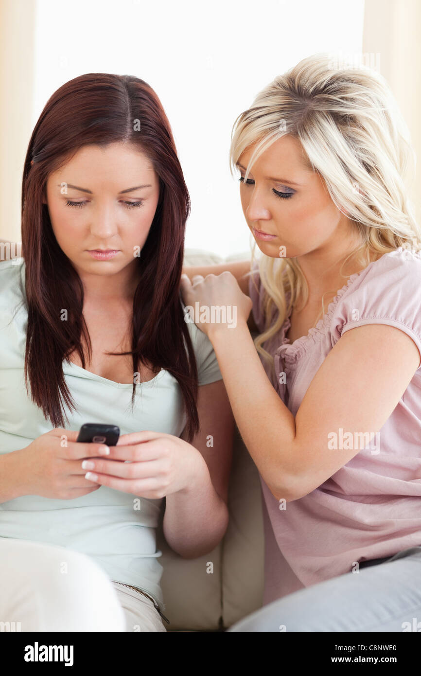 Shocked Women sitting on a sofa with a phone Stock Photo - Alamy