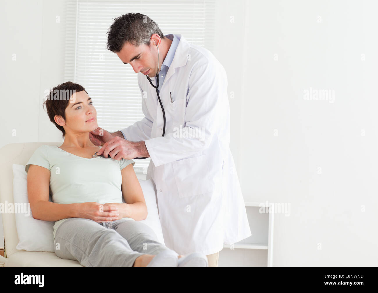 Male Doctor examining a patient Stock Photo - Alamy