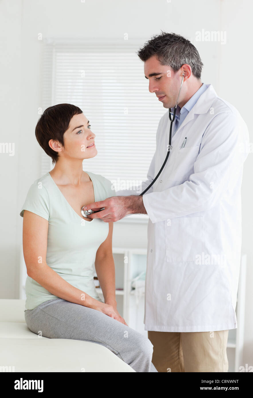 Doctor examining a brunette woman Stock Photo - Alamy
