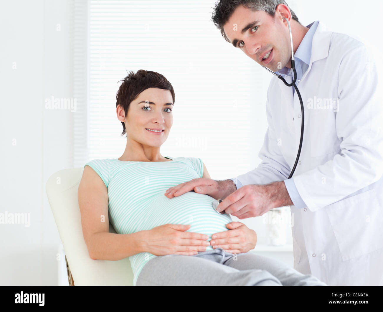 Doctor examining a tummy with a stethoscope Stock Photo - Alamy