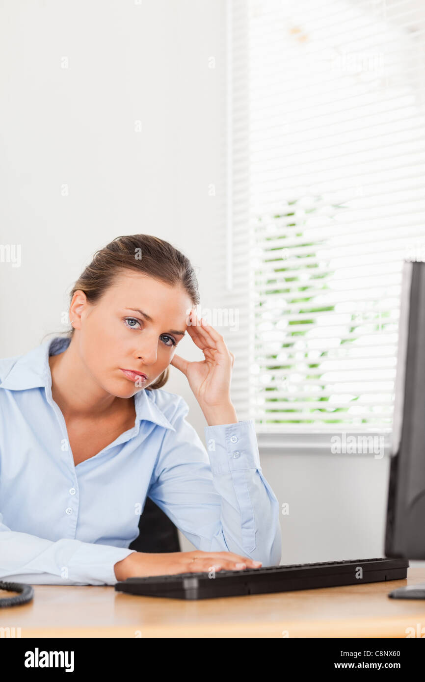 Businesswoman holding her head in office Stock Photo - Alamy