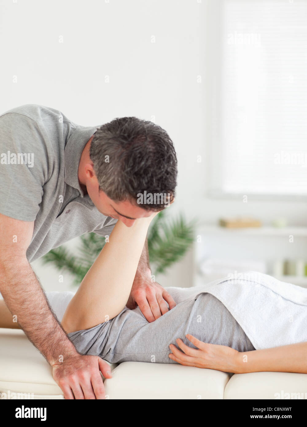 A chiropractor stretches woman's leg Stock Photo - Alamy