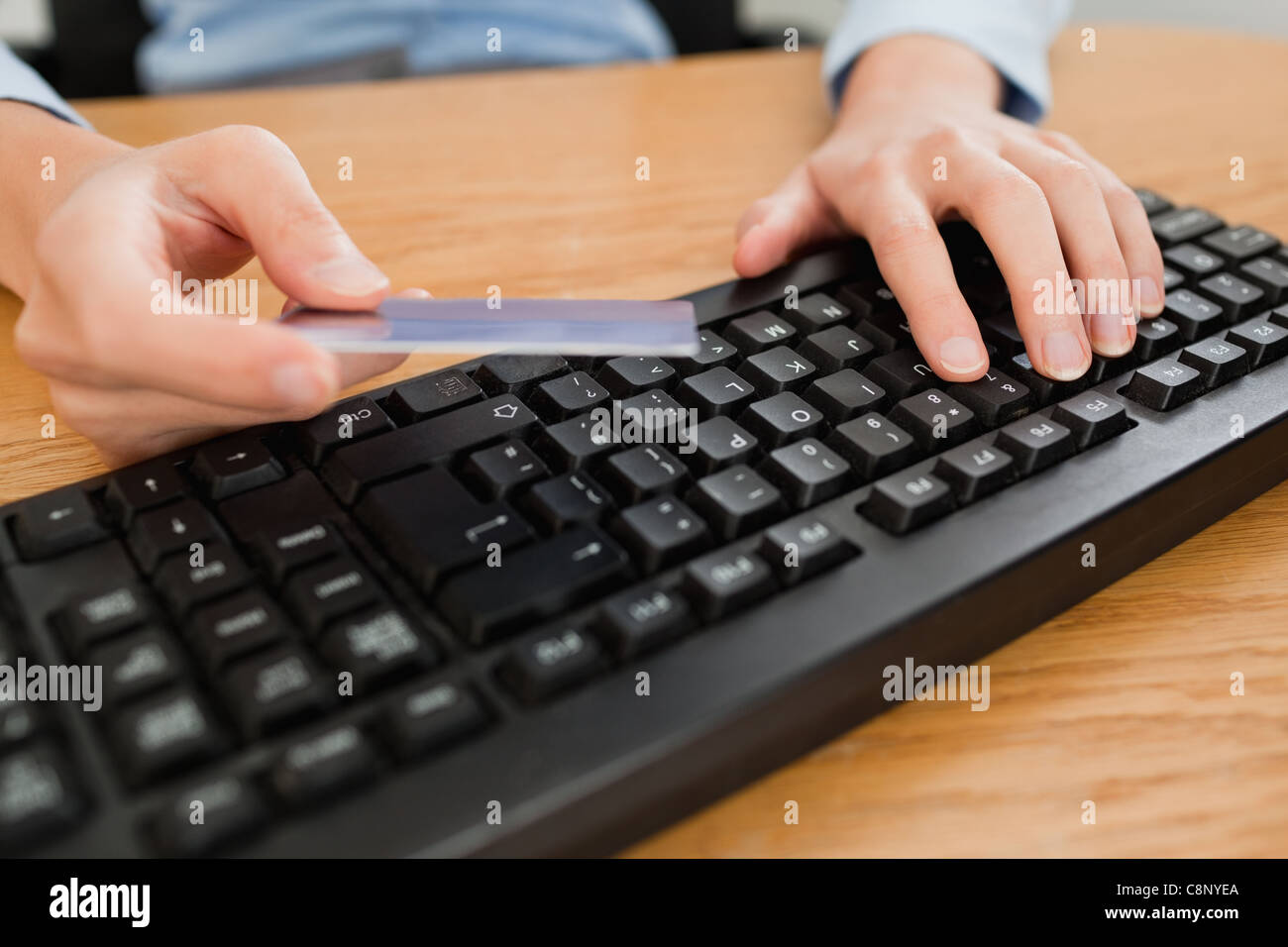 Woman typing on keyboard holding a credit card Stock Photo - Alamy