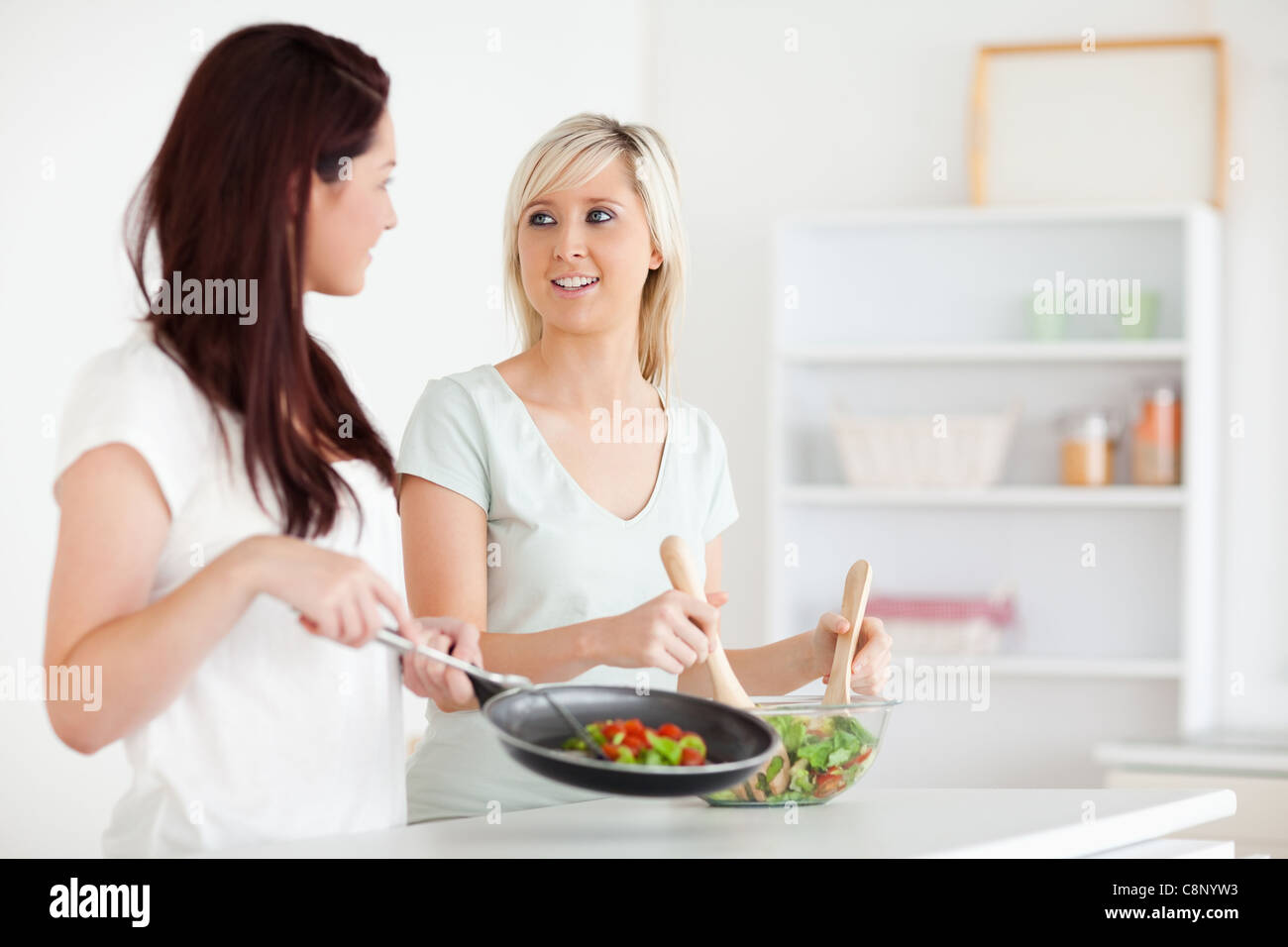 Smiling Women cooking dinner Stock Photo - Alamy