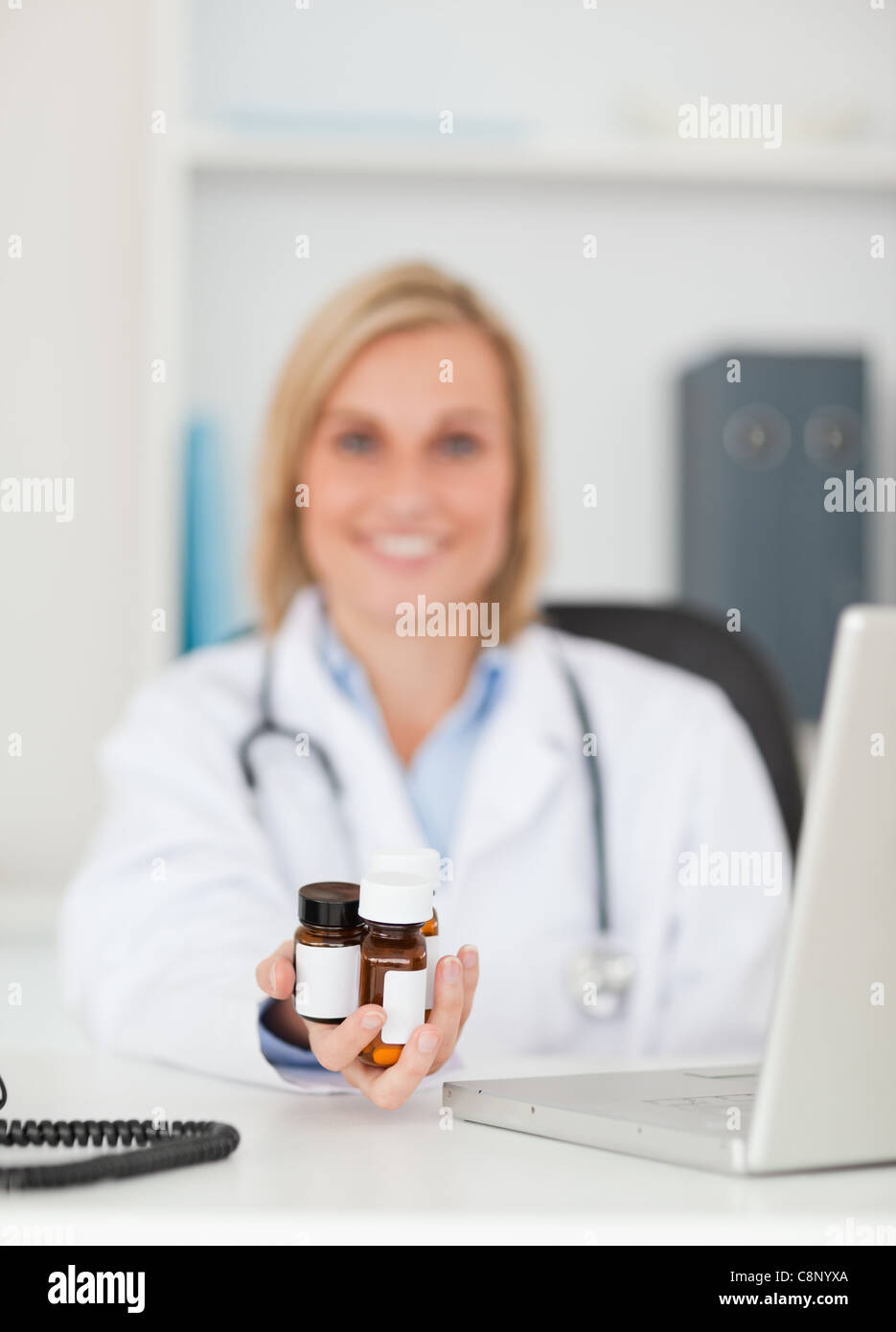 Smiling doctor presenting medicine Stock Photo - Alamy
