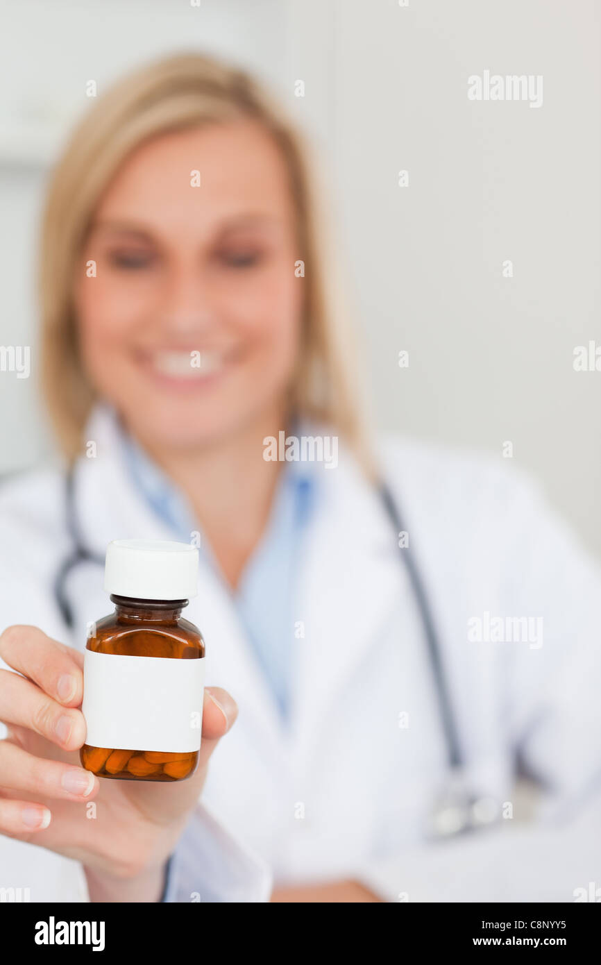 Smiling doctor holding medicine to camera Stock Photo - Alamy