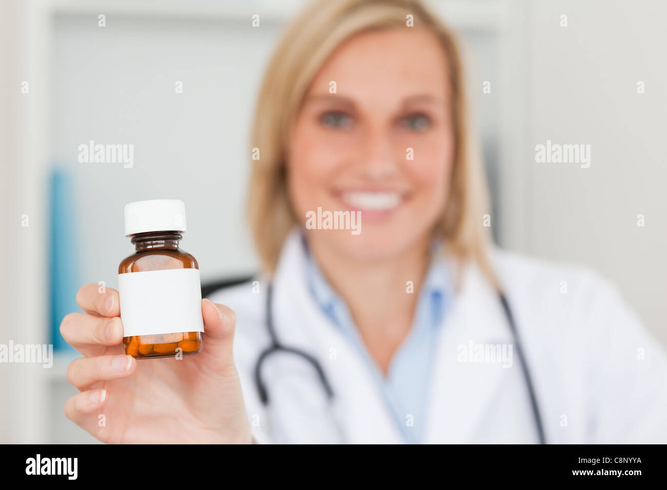 Gorgeous doctor holding medicine to camera Stock Photo - Alamy