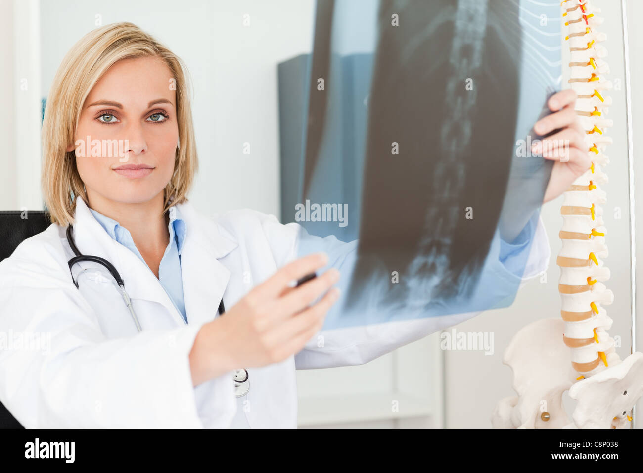 Serious doctor looking at x-ray looks into camera Stock Photo - Alamy