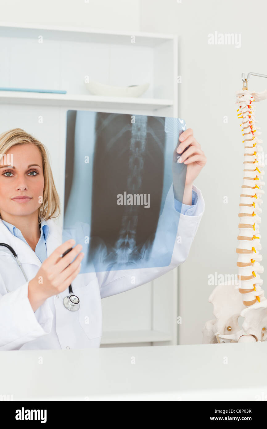 Sad looking doctor holding x-ray looking into camera Stock Photo - Alamy
