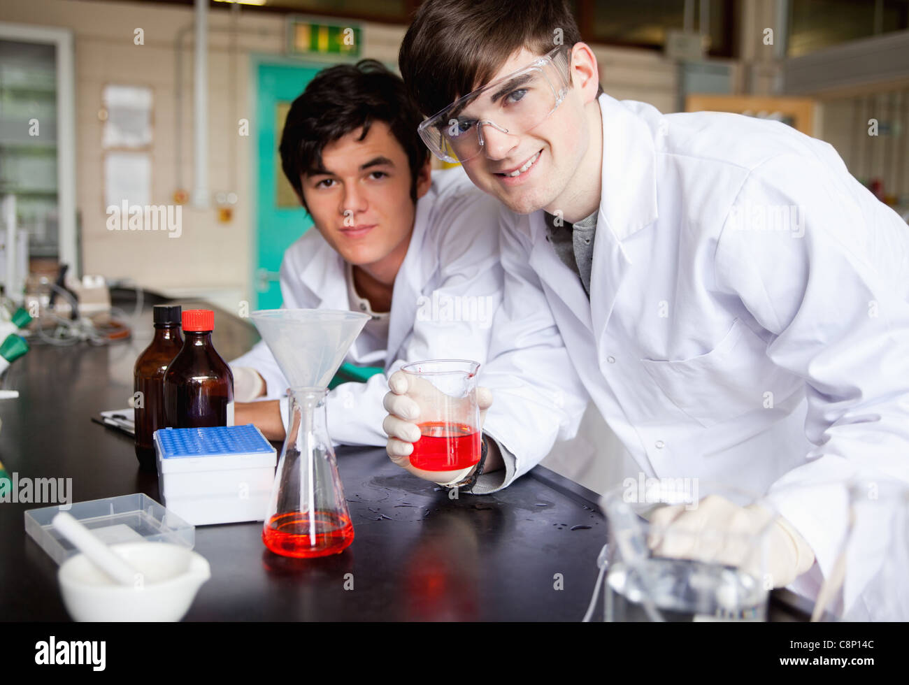 Students showing a red liquid Stock Photo - Alamy