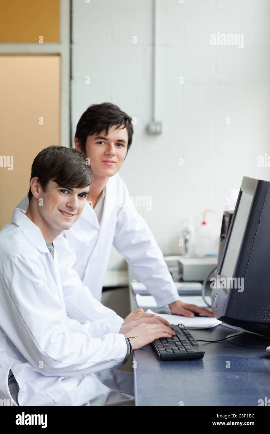 Portrait of scientists posing with a monitor Stock Photo - Alamy