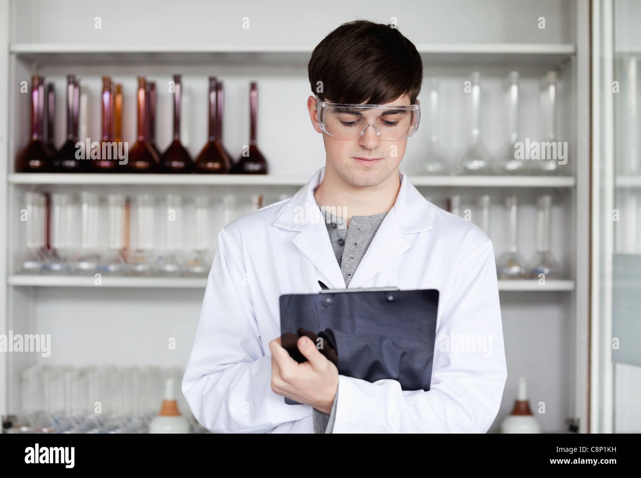 Male scientist writing on a clipboard Stock Photo - Alamy