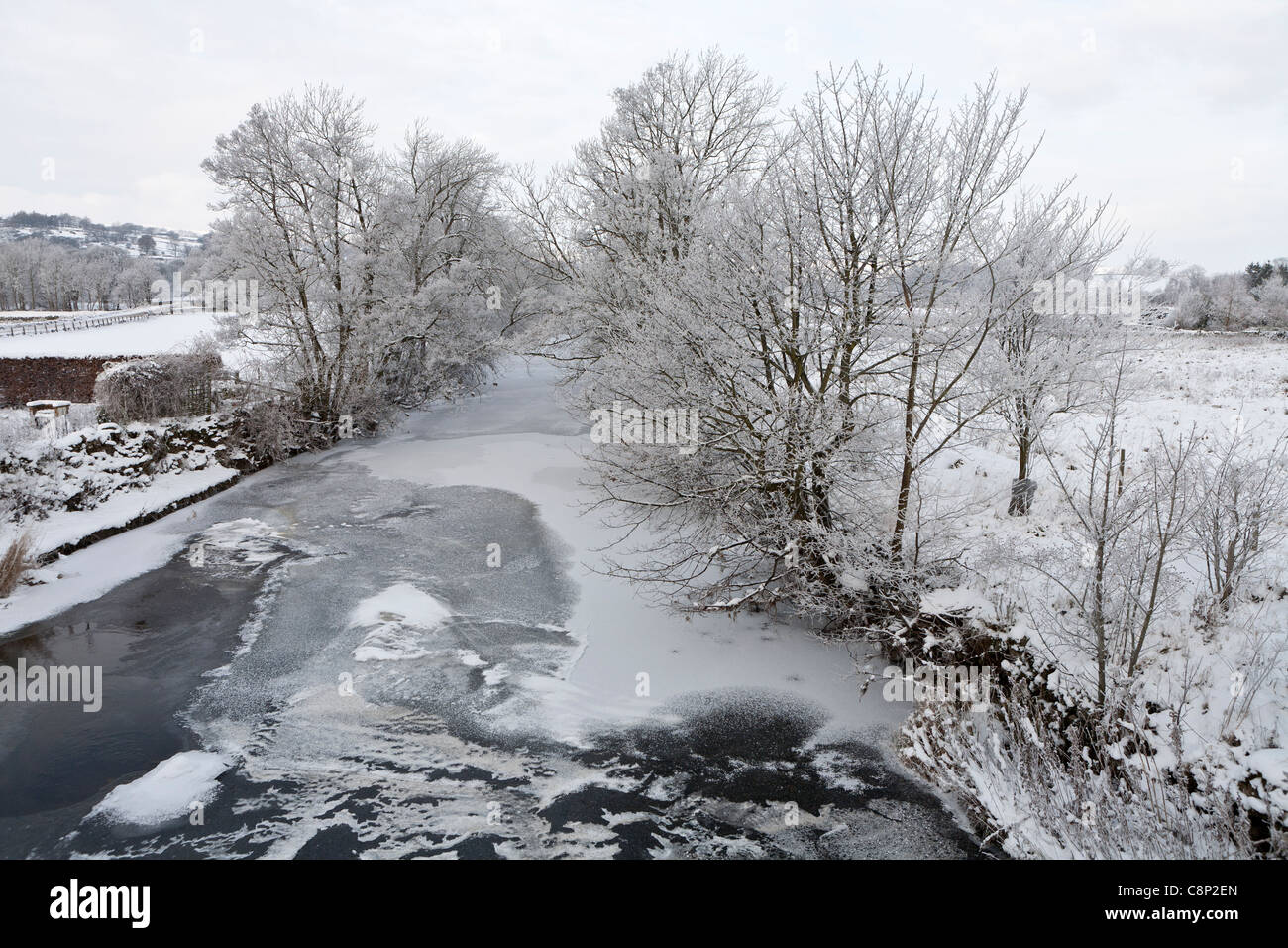 Winter scene from bridge over frozen river with snow and ice on the ...