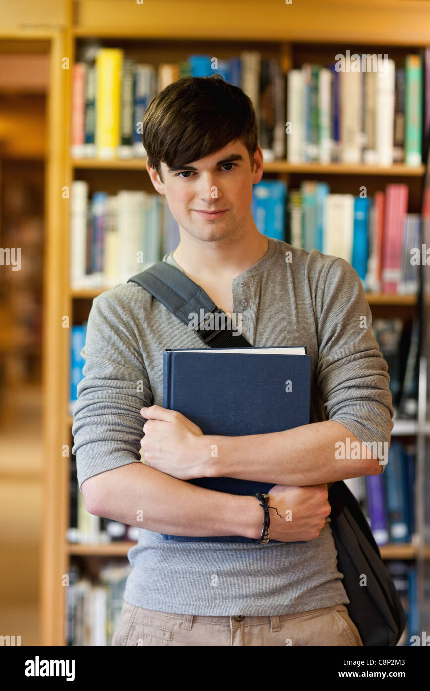 Portrait of young student holding a book Stock Photo - Alamy