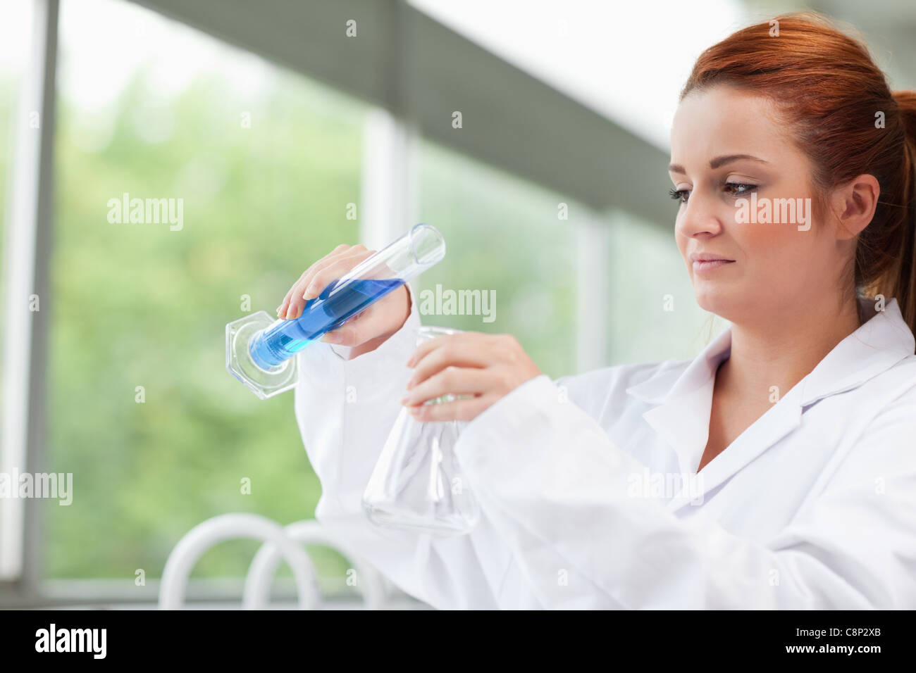 Science student pouring liquid in an Erlenmeyer flask Stock Photo - Alamy