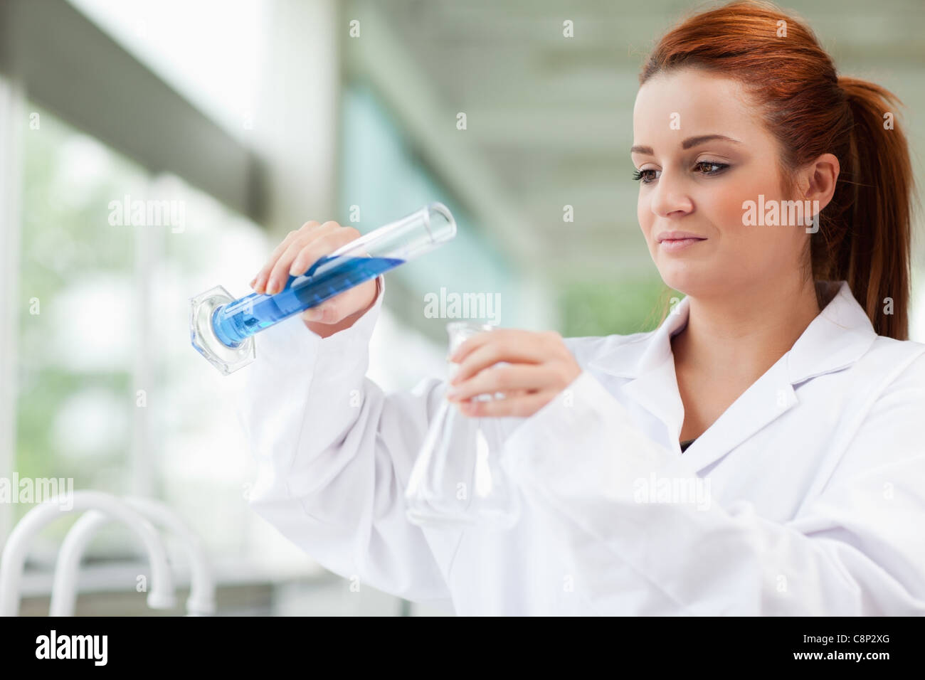 Scientist pouring liquid in an Erlenmeyer flask Stock Photo - Alamy