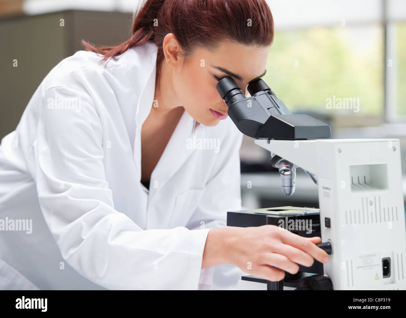 Young scientist looking into a microscope Stock Photo - Alamy