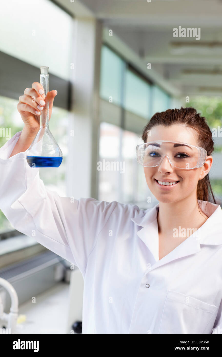 Portrait of a female science student holding a blue liquid Stock Photo ...
