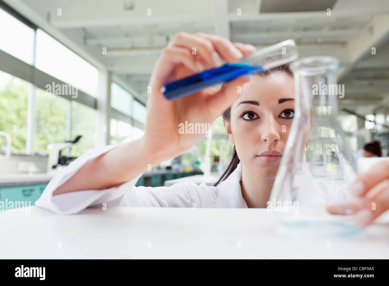 Focused science student pouring liquid Stock Photo - Alamy