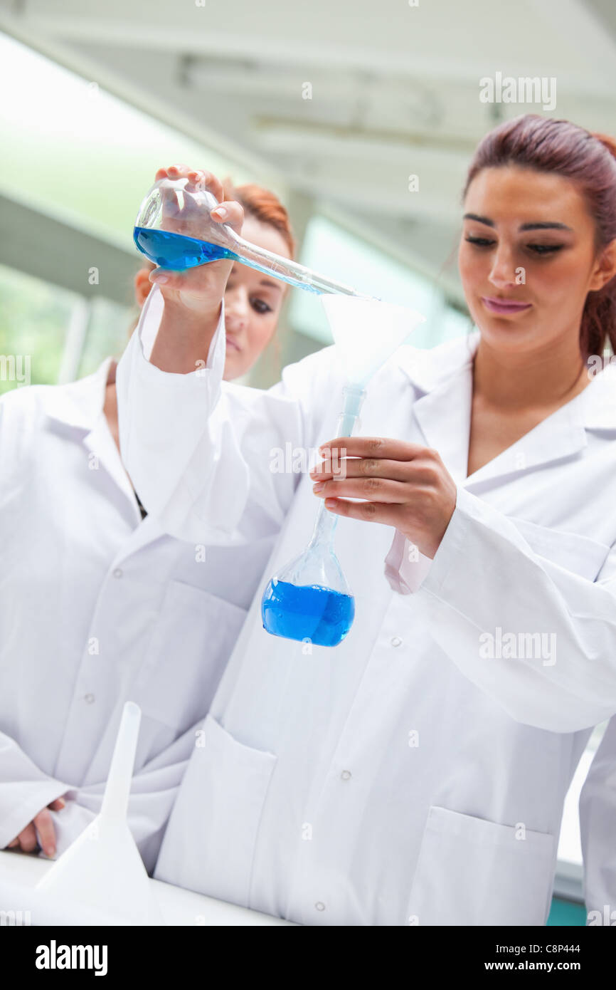 Portrait of smiling scientists pouring liquid into a flask Stock Photo ...