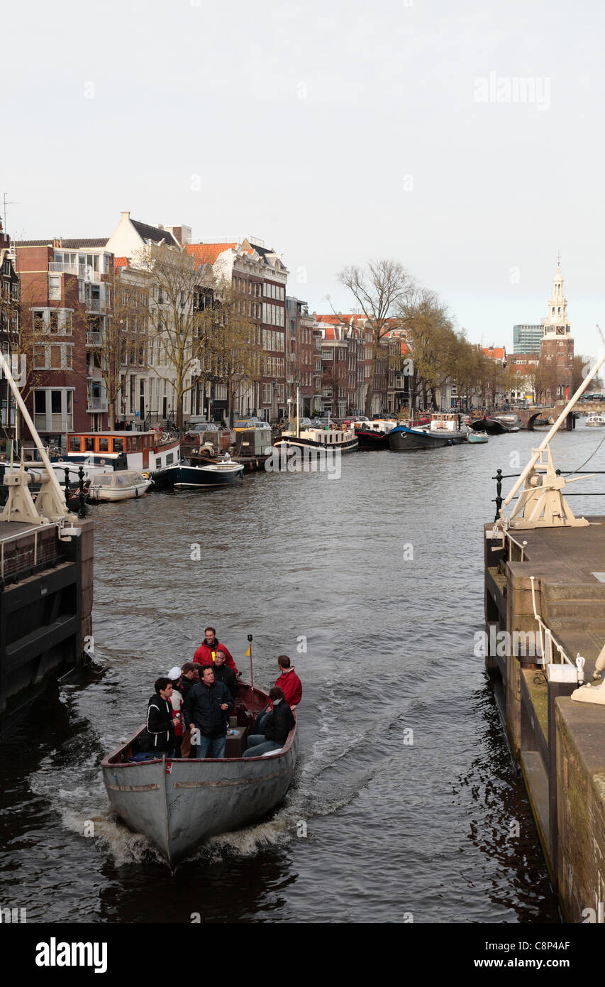 Small boat going through canal lock gates on a canal Amsterdam Holland ...