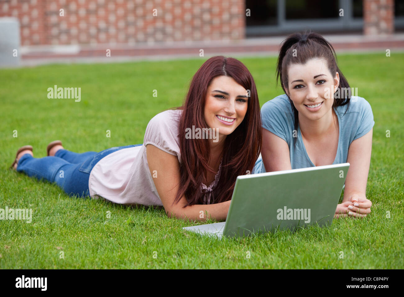 Friends using a notebook Stock Photo - Alamy