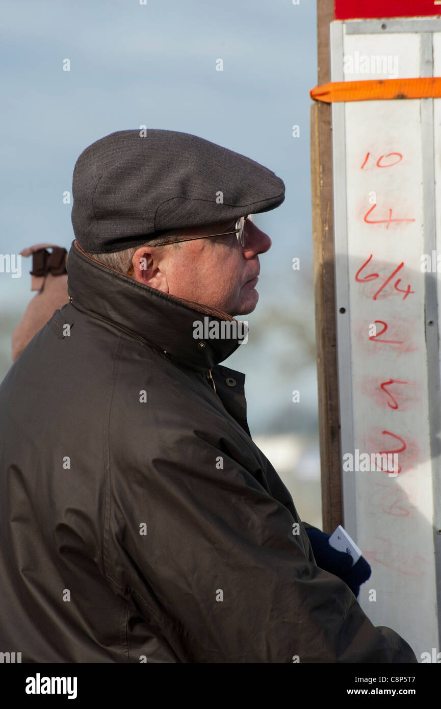 Bookmaker or bookie standing by his stall with the odds displayed for a ...