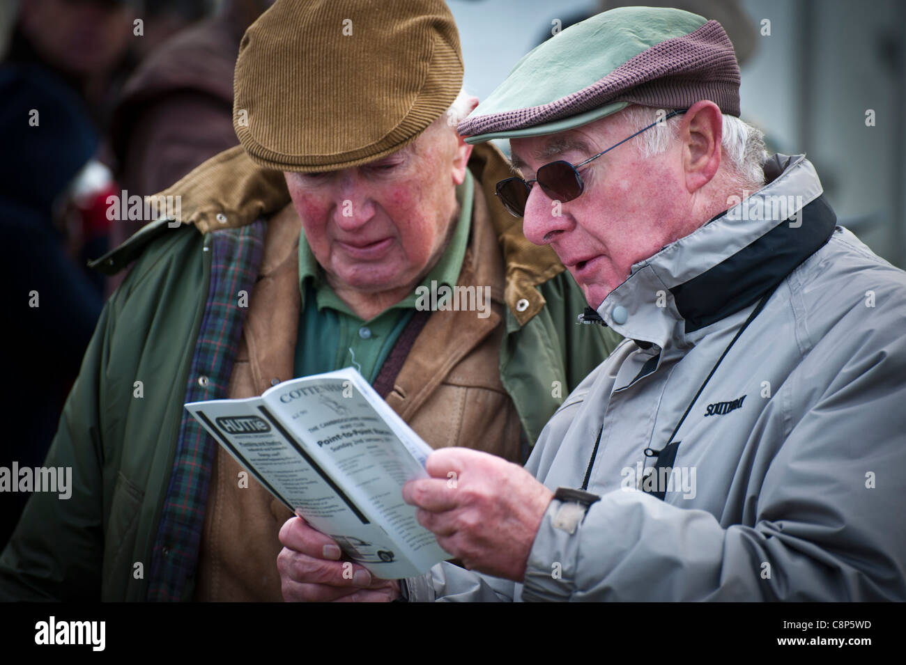 Two older men study the racing programme at a horse racing event Stock ...