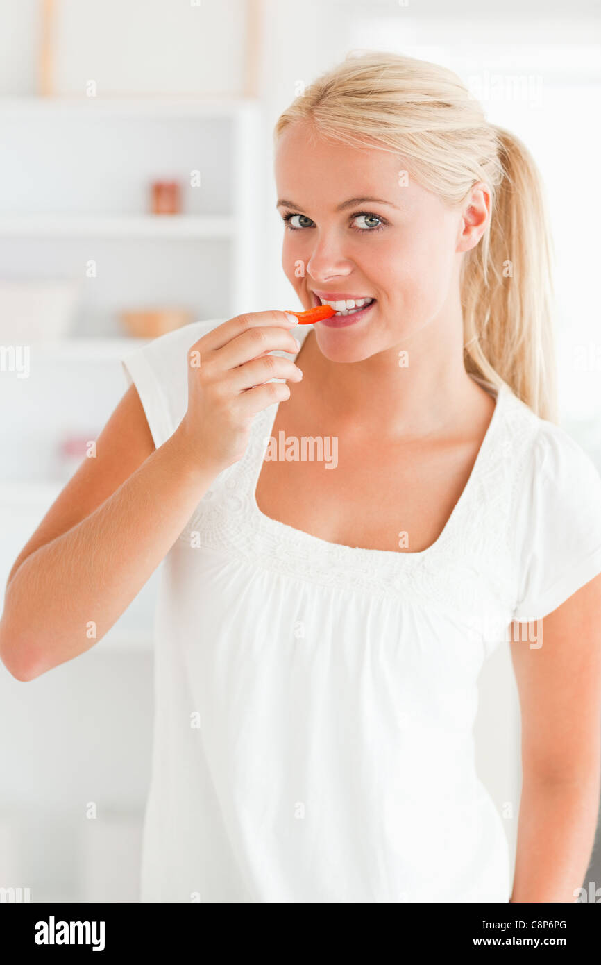 Portrait of a woman eating a slice of pepper Stock Photo - Alamy